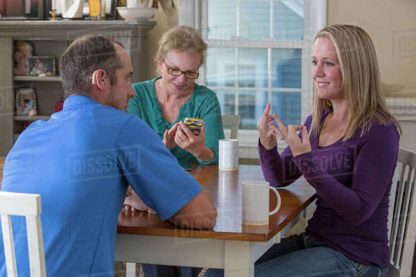 Deaf Caucasian friends signing at dinner table - Royalty-free Stock ...