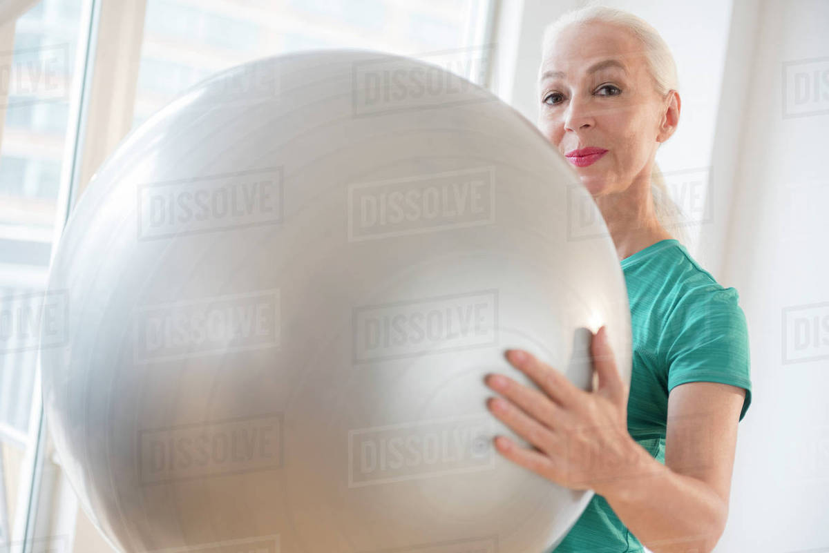 Caucasian woman holding fitness ball - Royalty-free Stock Photo | Dissolve