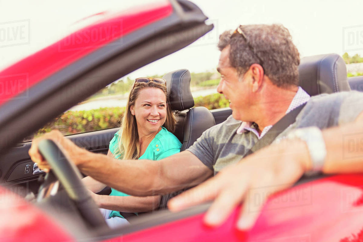 Caucasian couple driving convertible - Stock Photo - Dissolve