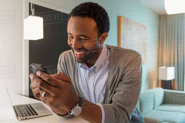 Black man using cell phone in living room - Royalty-free Stock Photo ...