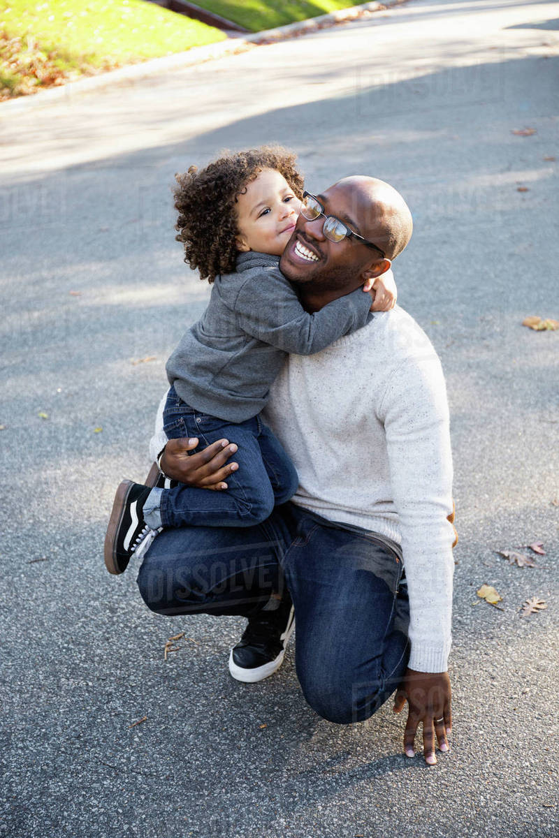 Boy hugging father outdoors - Royalty-free Stock Photo | Dissolve
