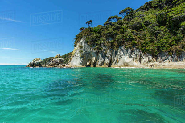 Cliff over ocean in remote beach - Royalty-free Stock Photo | Dissolve