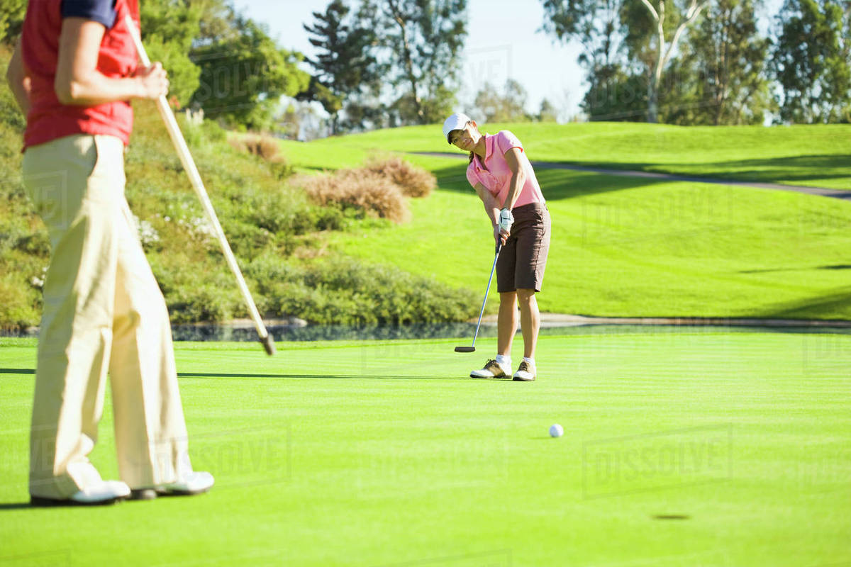 Women putting on green at golf course - Royalty-free Stock Photo | Dissolve