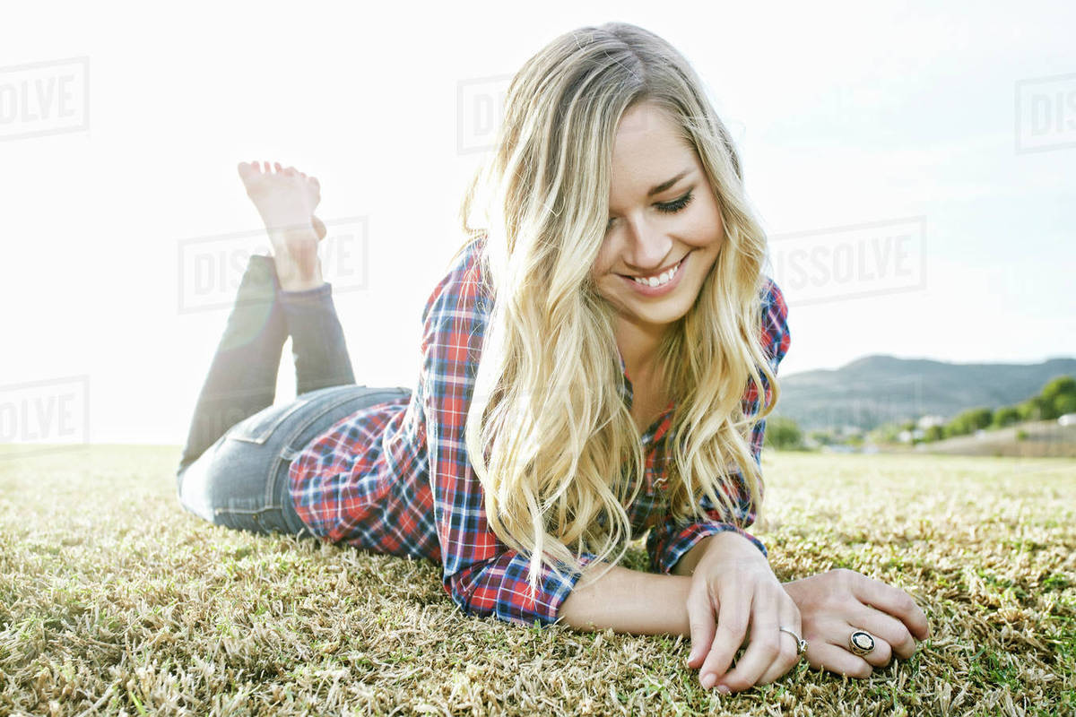 Caucasian woman laying in park - Royalty-free Stock Photo | Dissolve