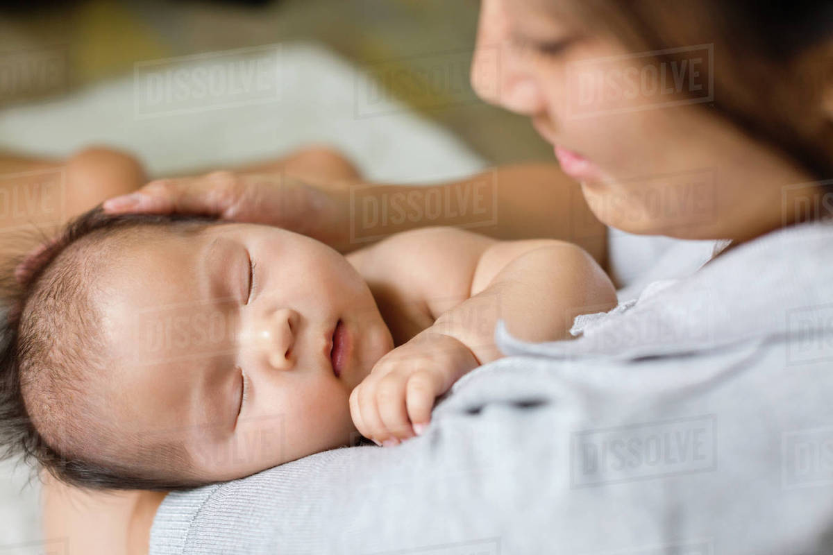 Mother holding sleeping baby - Royalty-free Stock Photo | Dissolve