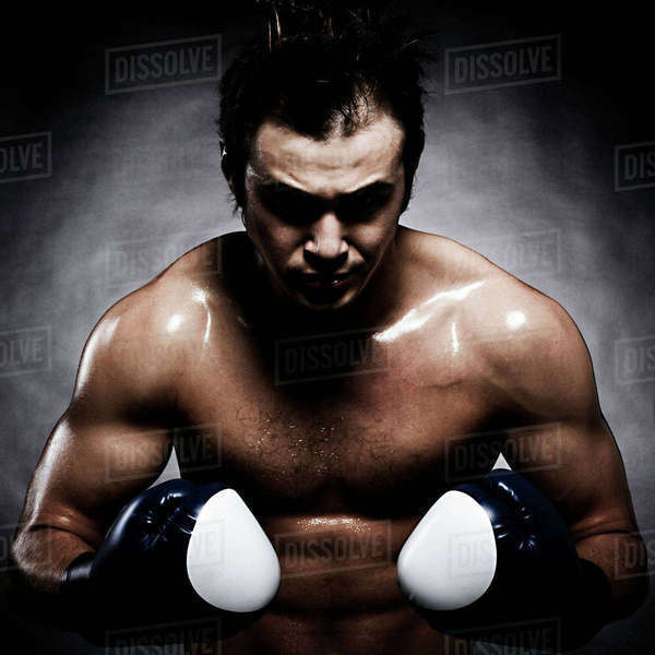 Caucasian boxer flexing his muscles - Stock Photo - Dissolve