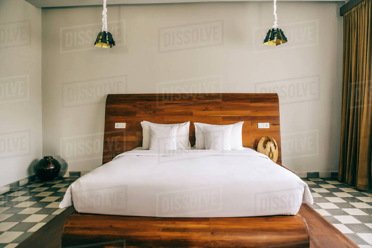 Empty bed in modern hotel room - Royalty-free Stock Photo | Dissolve