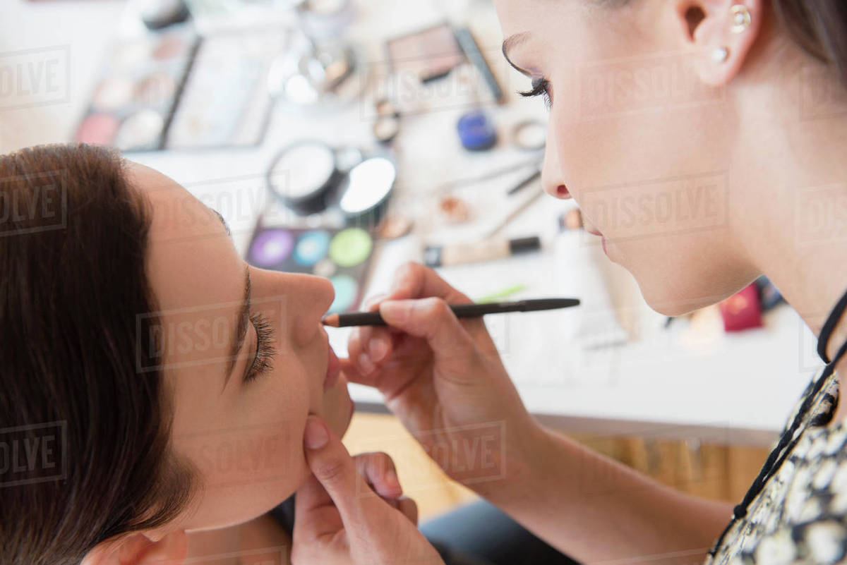 Woman having makeup applied by stylist - Stock Photo - Dissolve