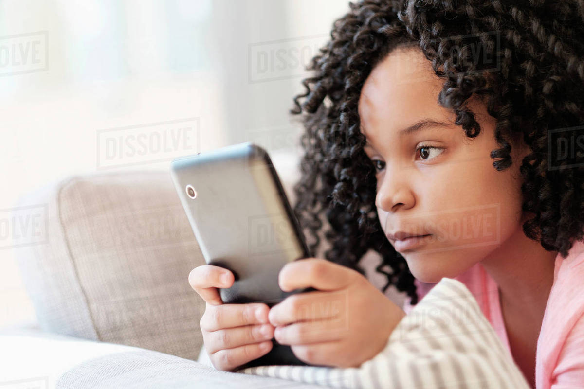 African American girl using cell phone on sofa - Royalty-free Stock ...