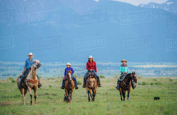 Cowboy and cowgirls riding horseback on ranch - Royalty-free Stock ...