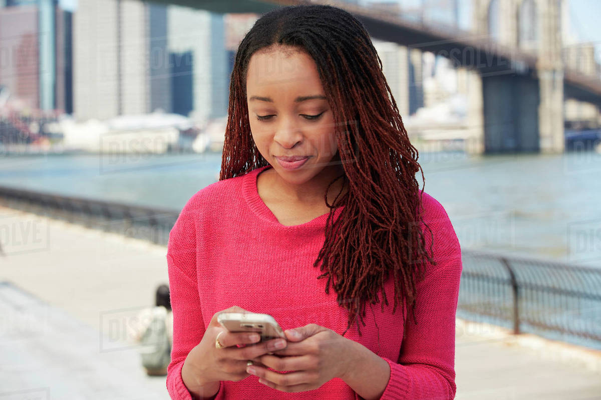 Black woman using cell phone at waterfront - Royalty-free Stock Photo ...