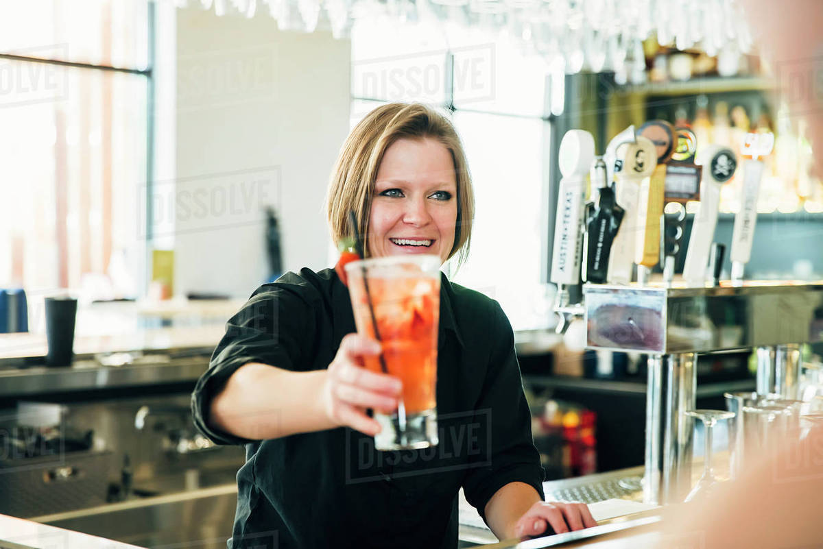 Caucasian bartender serving cocktail - Stock Photo - Dissolve