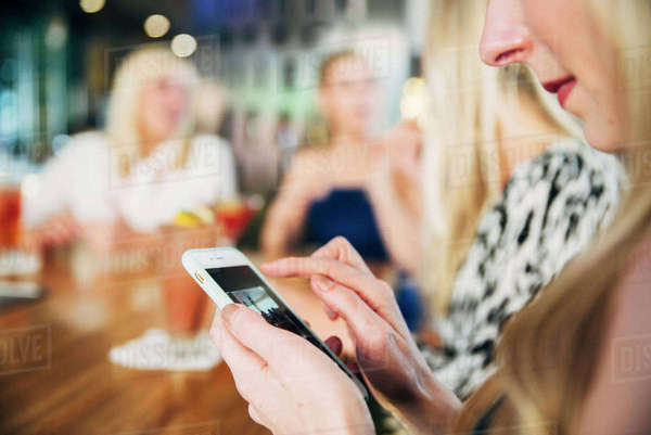 Caucasian woman using cell phone at bar - Royalty-free Stock Photo ...