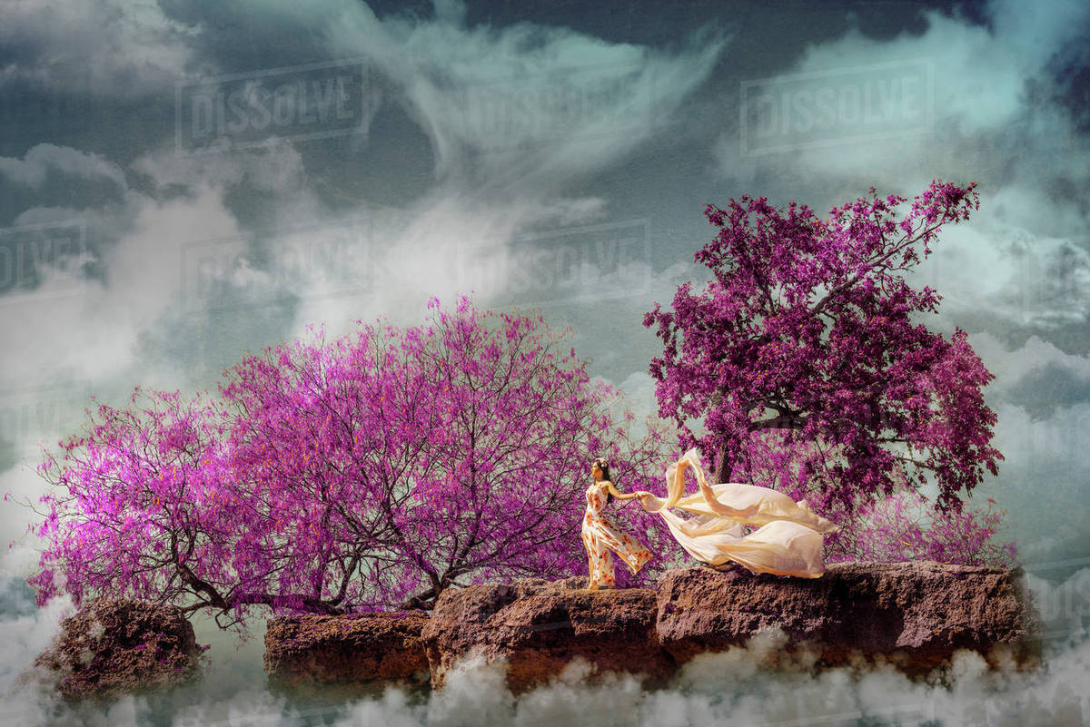 Chinese woman holding fabric in fog on windy rock - Stock Photo - Dissolve