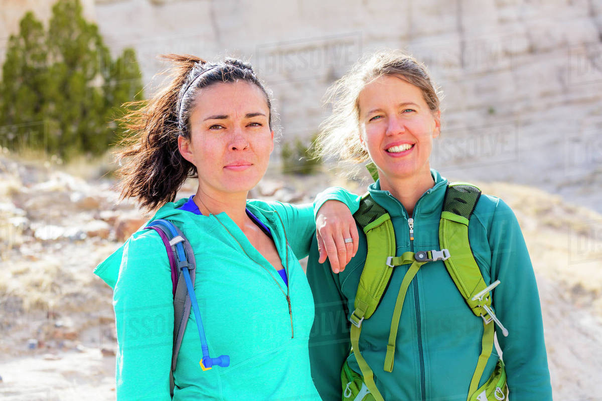 Confident women standing in canyon wearing backpacks - Royalty-free ...