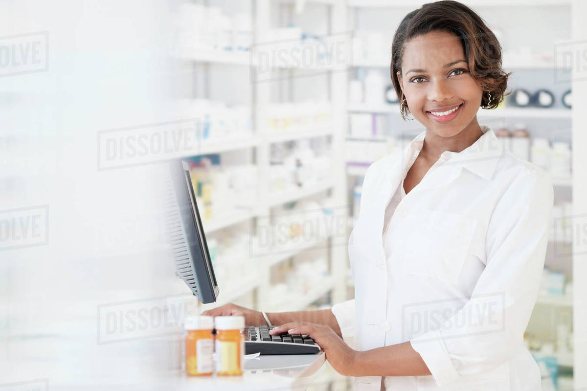 Smiling Black pharmacist using computer - Royalty-free Stock Photo ...
