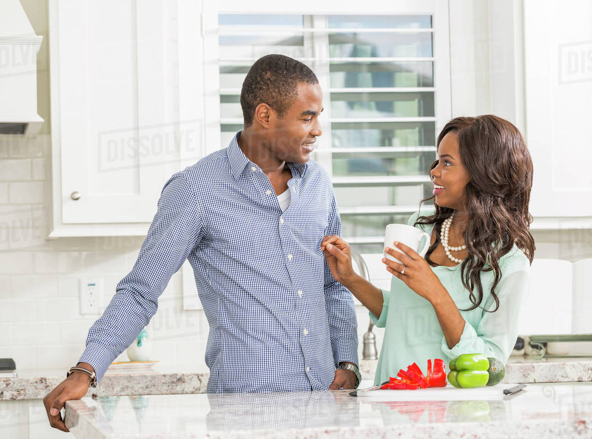 Black couple smiling in kitchen - Royalty-free Stock Photo | Dissolve