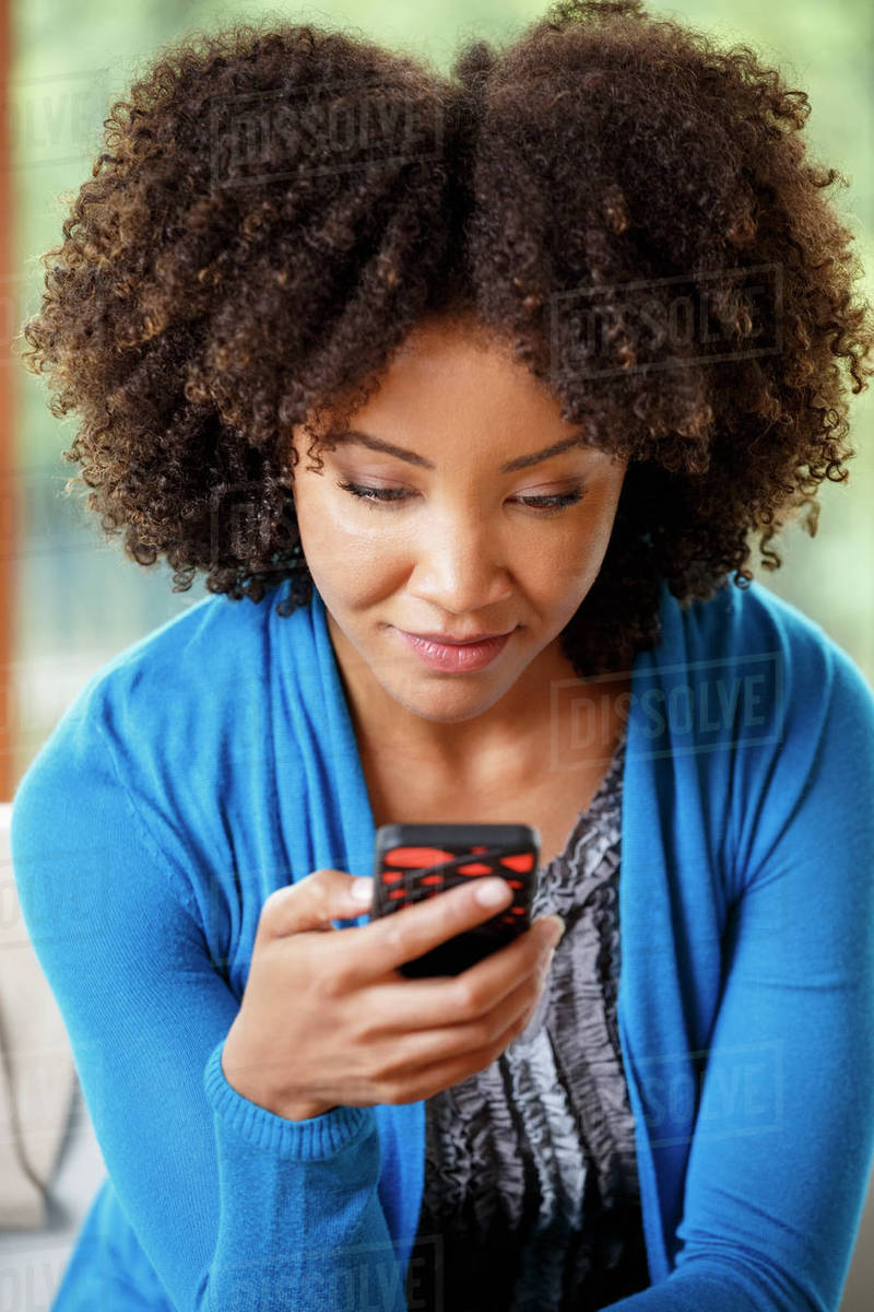 Black woman texting on cell phone - Royalty-free Stock Photo | Dissolve