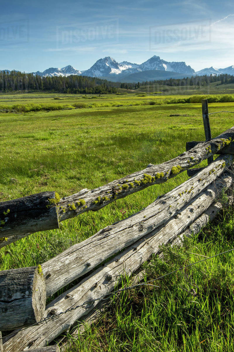 Wooden log fence in field near mountain range - Royalty-free Stock ...