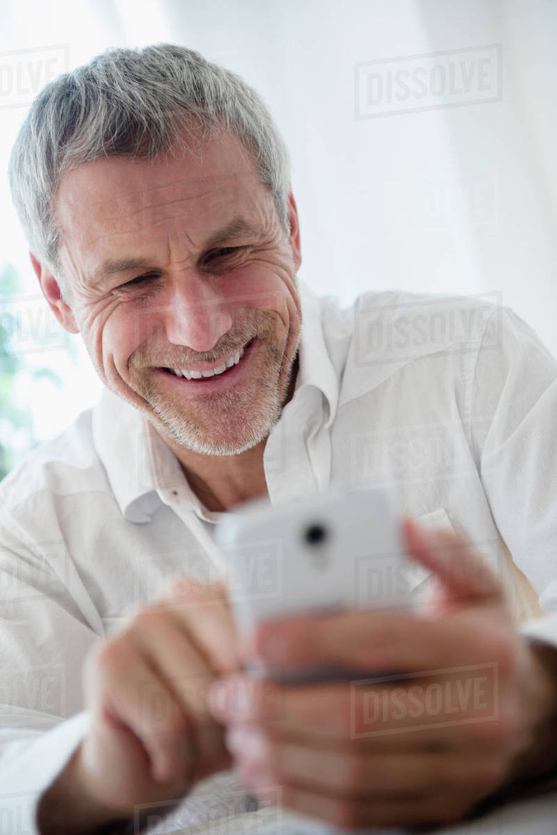 Older Caucasian man using cell phone - Royalty-free Stock Photo | Dissolve
