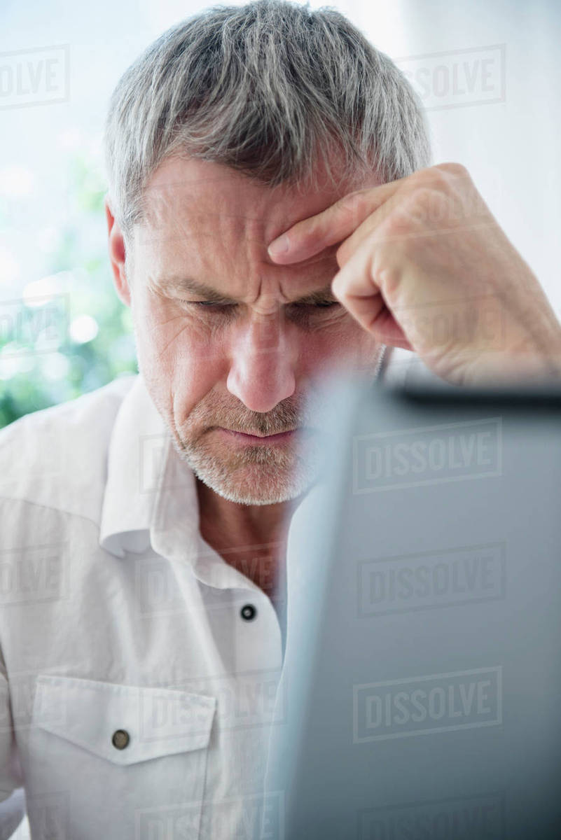 Frustrated older Caucasian man using laptop - Royalty-free Stock Photo ...