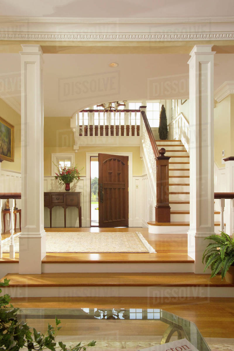Foyer of traditional home with staircase and pillars - Royalty-free ...