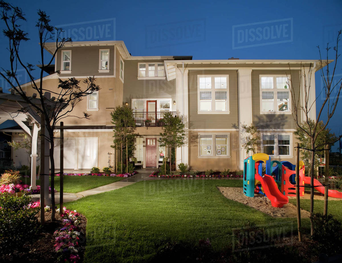 Exterior of attached homes in the evening with playground - Royalty ...