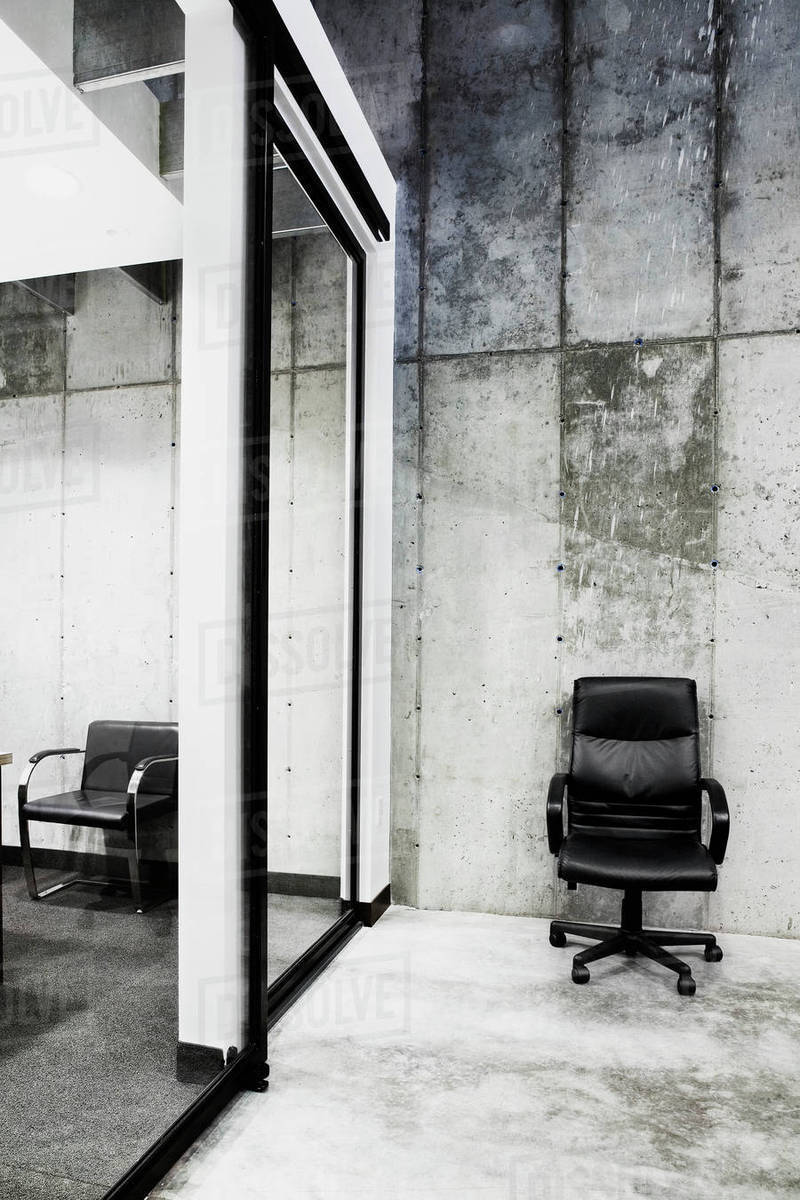 Detail of a lone leather office chair in modern office building - Stock ...