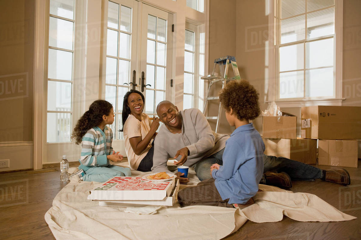 Family eating on floor in new home - Stock Photo - Dissolve
