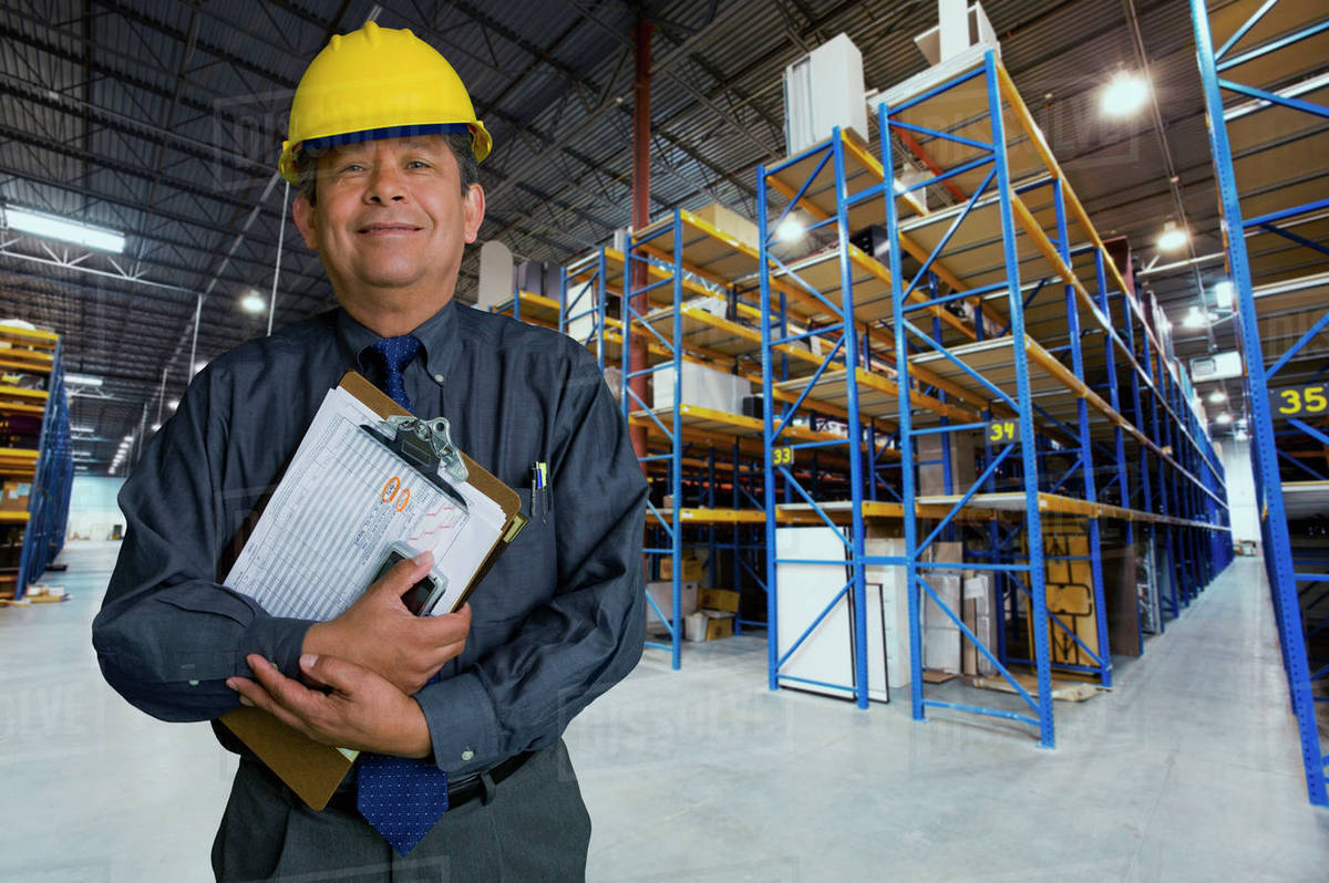 Hispanic man working in warehouse - Stock Photo - Dissolve
