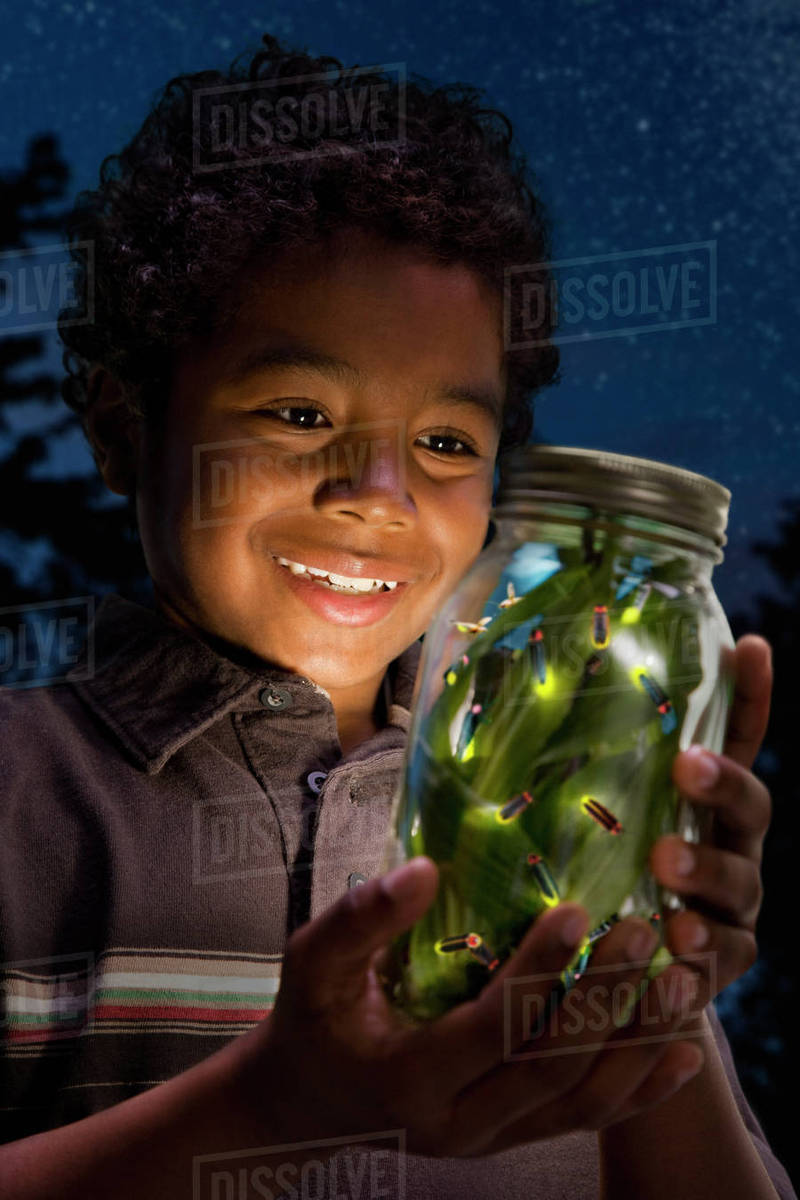 African boy looking at fireflies in jar - Royalty-free Stock Photo ...