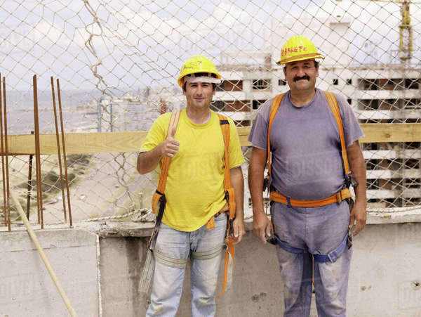 Hispanic workers smiling on construction site - Royalty-free Stock ...