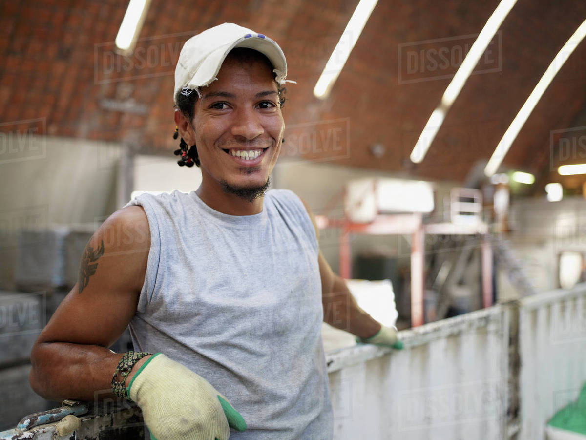 Hispanic worker smiling in factory - Royalty-free Stock Photo | Dissolve