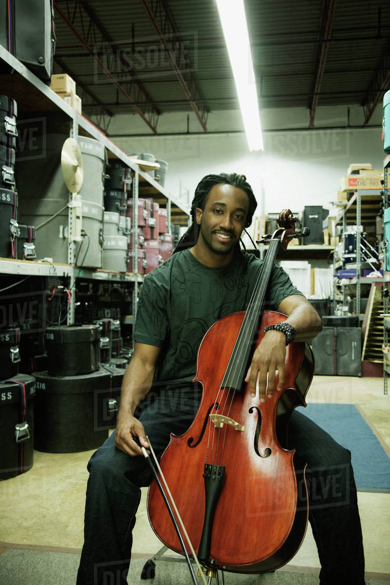 African man with cello in warehouse - Royalty-free Stock Photo | Dissolve