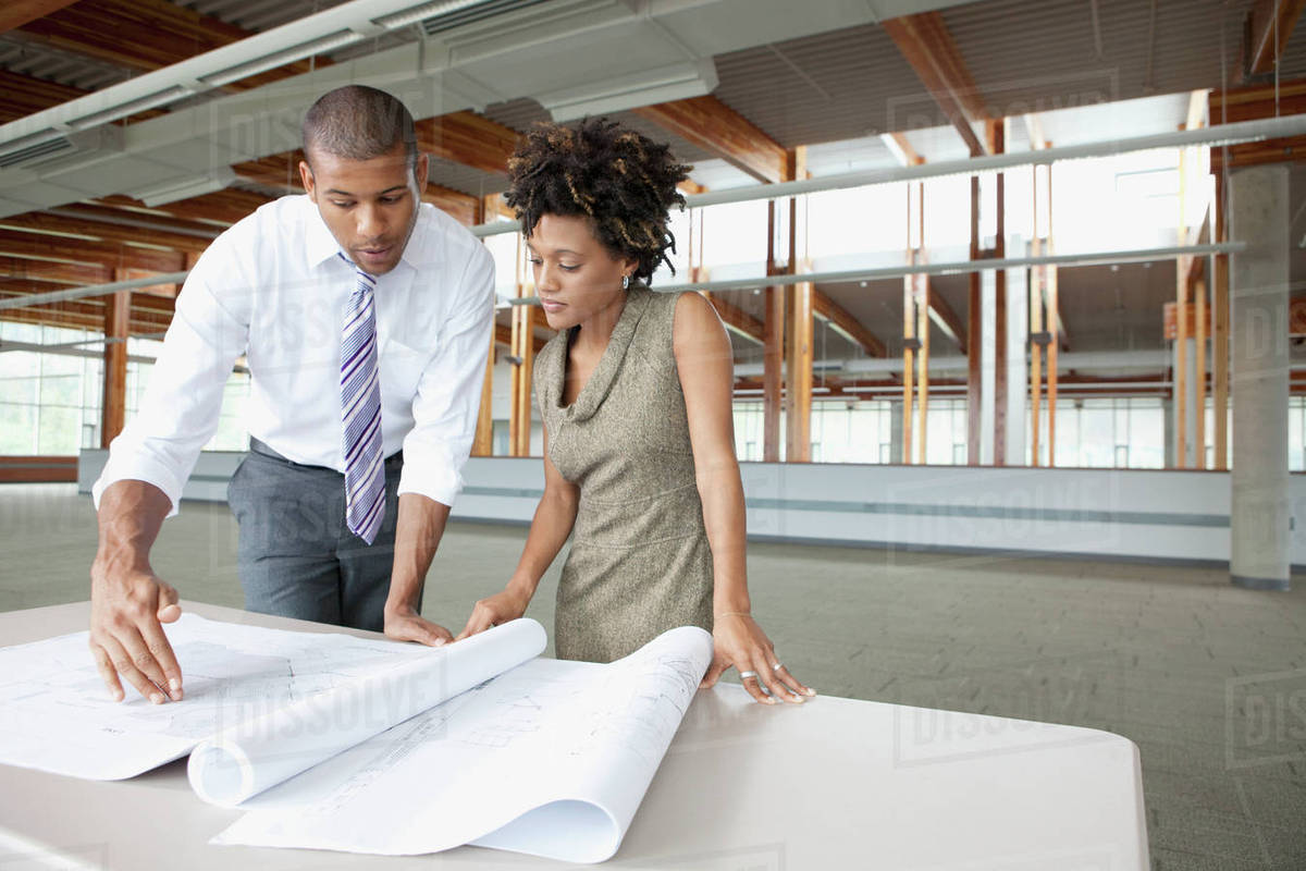 Business people looking at blueprints - Royalty-free Stock Photo | Dissolve