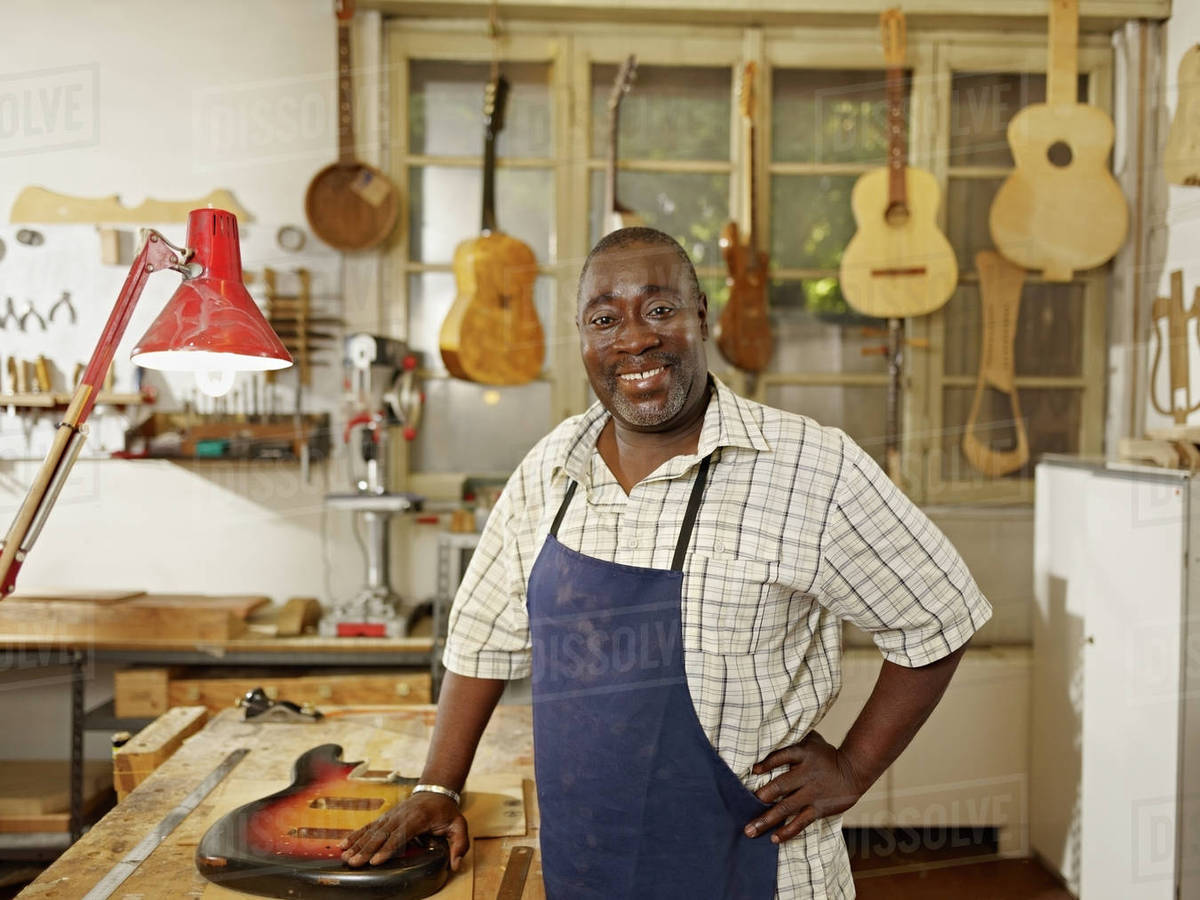 Black craftsman in guitar workshop - Royalty-free Stock Photo | Dissolve