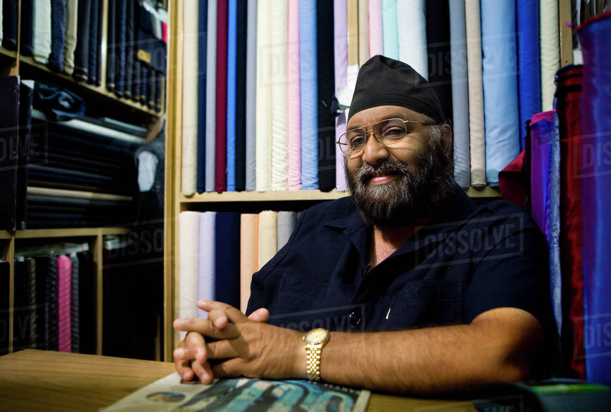 Indian business owner sitting in fabric store - Royalty-free Stock ...