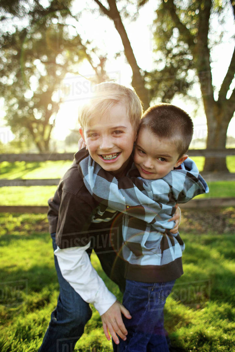 Caucasian brothers hugging outdoors - Stock Photo - Dissolve