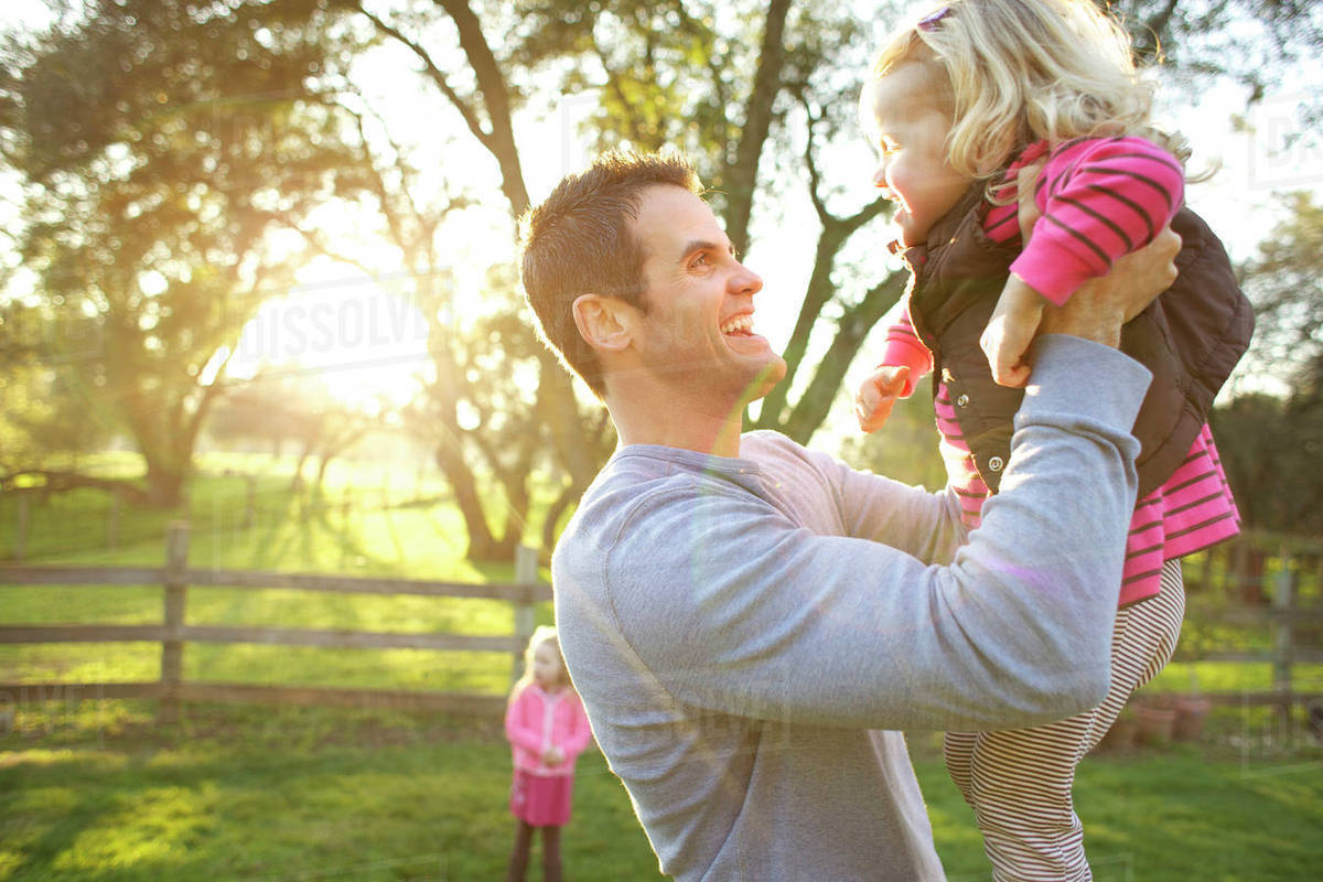 Caucasian father lifting daughter - Stock Photo - Dissolve