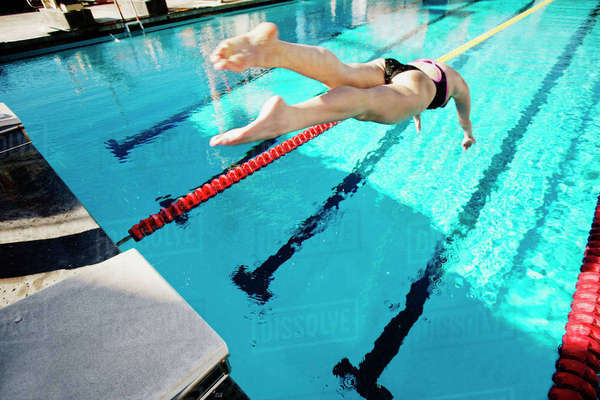 Competitive swimmer diving into swimming pool - Stock Photo - Dissolve