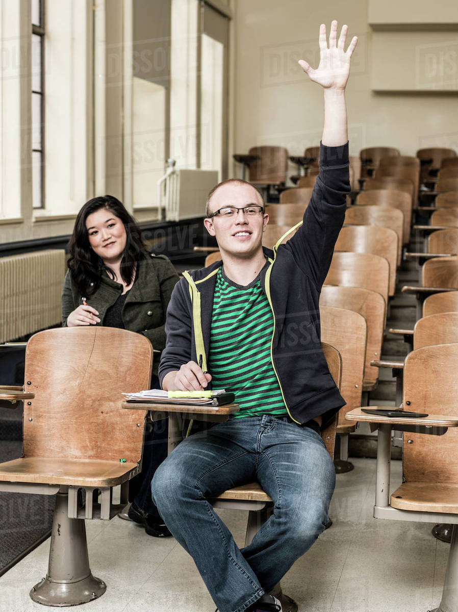 Student raising his hand in classroom - Royalty-free Stock Photo | Dissolve