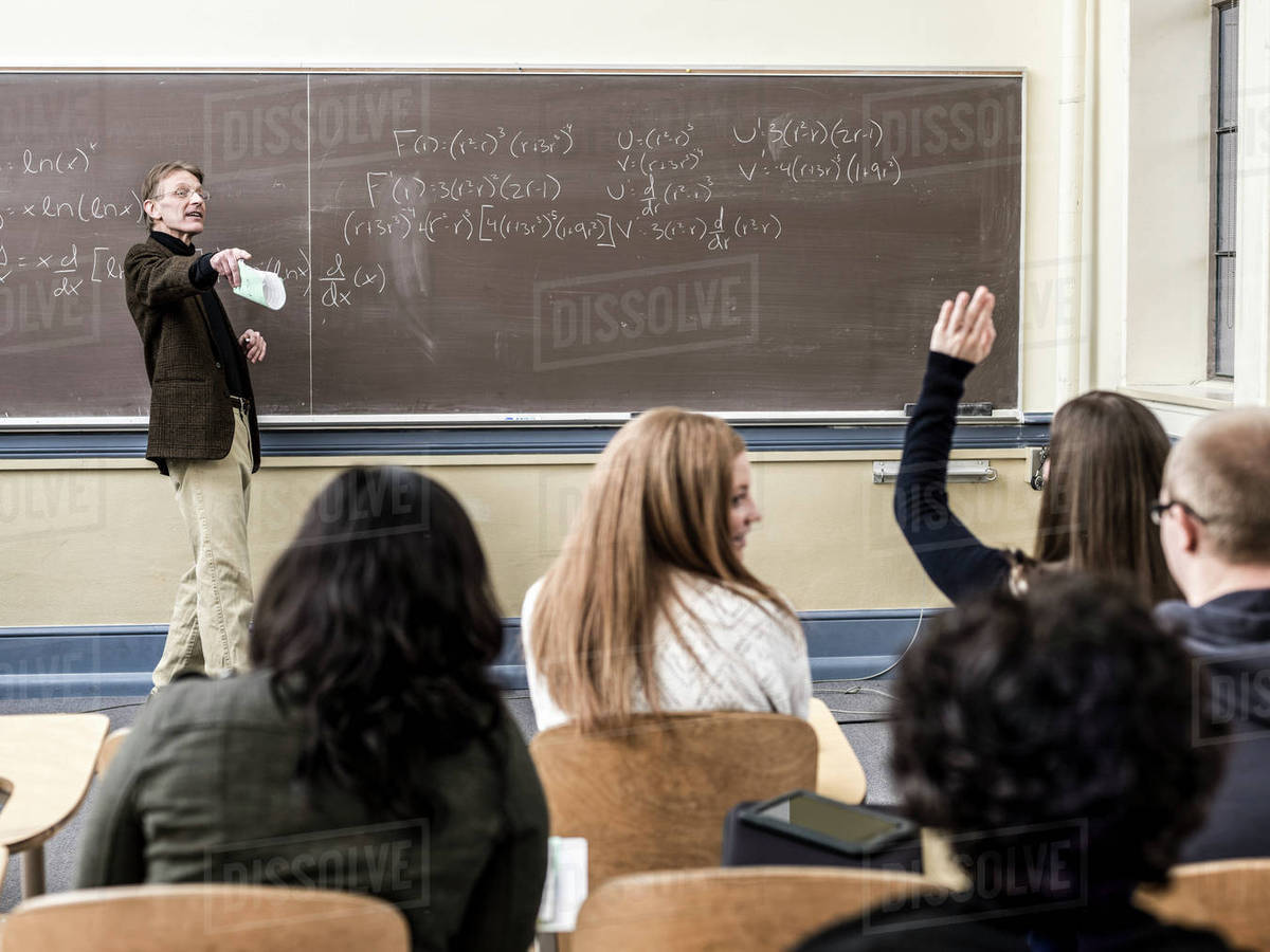 Teacher talking to students in classroom - Royalty-free Stock Photo ...