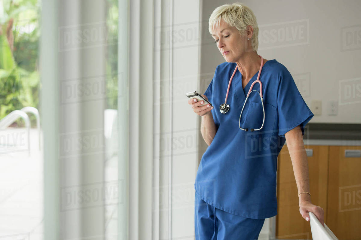 Caucasian doctor text messaging on cell phone - Royalty-free Stock ...