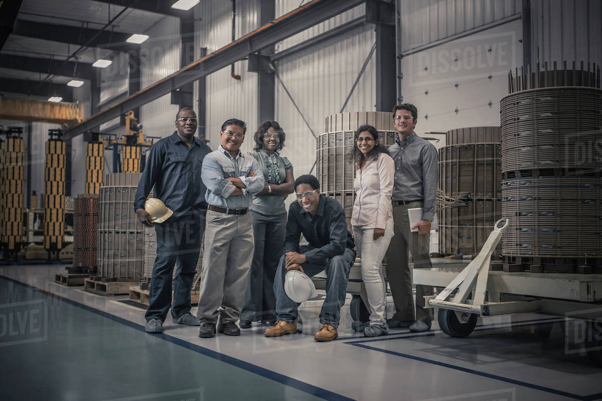 Workers standing together in factory - Royalty-free Stock Photo | Dissolve