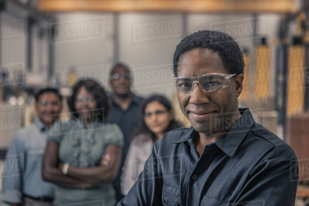 Workers standing together in factory - Royalty-free Stock Photo | Dissolve