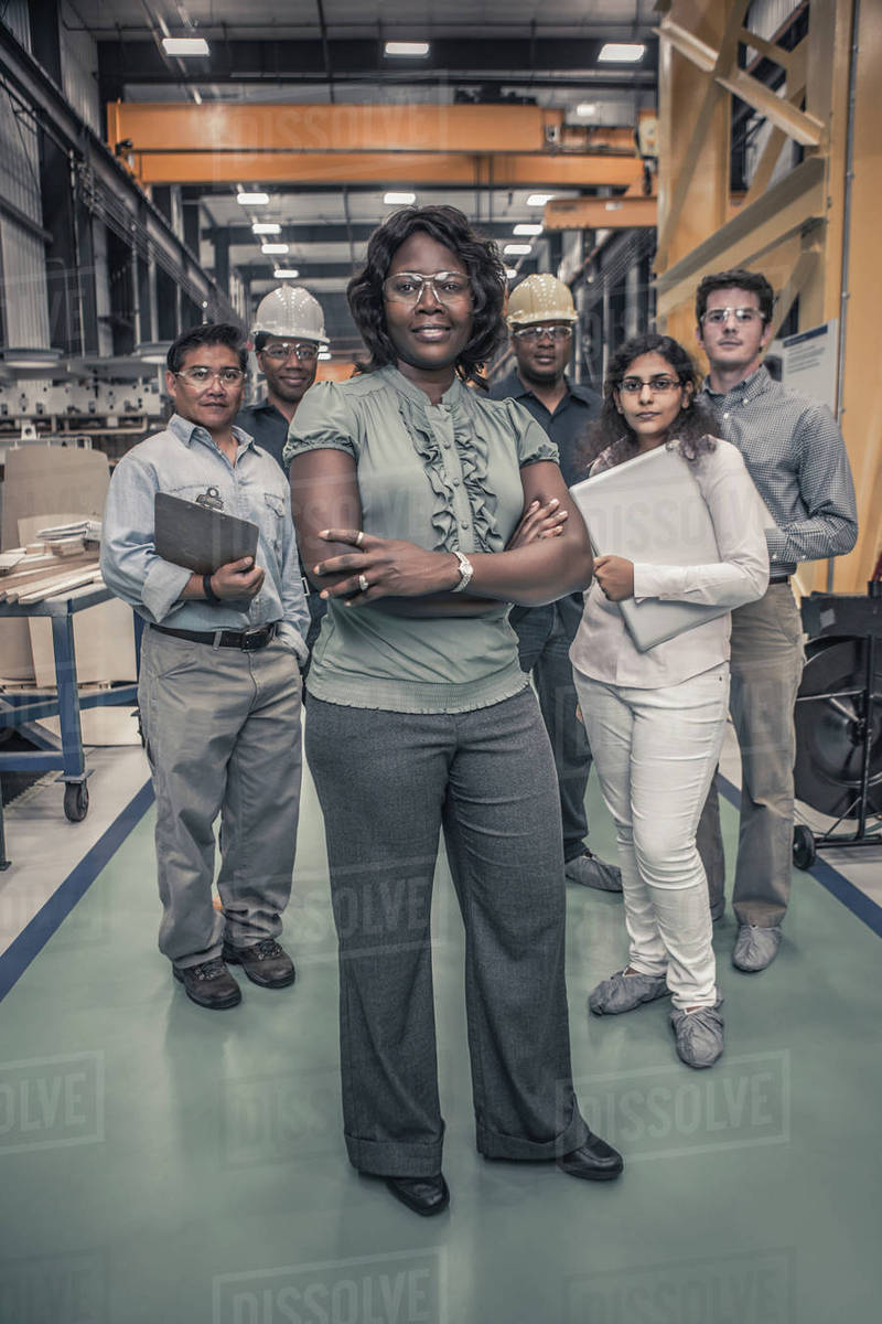 Workers standing together in factory - Royalty-free Stock Photo | Dissolve