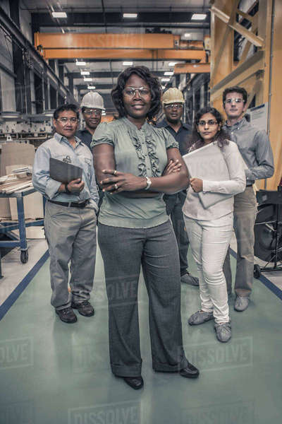 Workers standing together in factory - Royalty-free Stock Photo | Dissolve