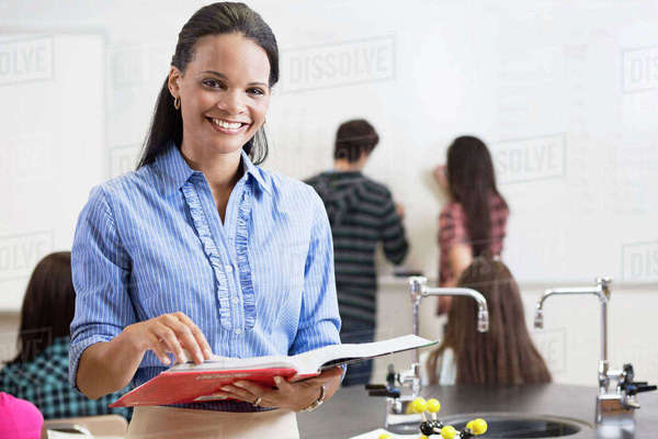 Black teacher holding book in classroom - Royalty-free Stock Photo ...
