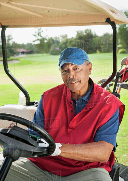 Black man driving golf cart - Stock Photo - Dissolve