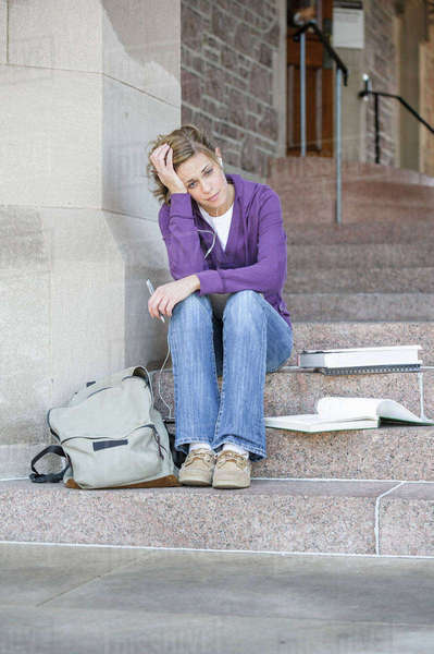 Caucasian student sitting on campus - Royalty-free Stock Photo | Dissolve